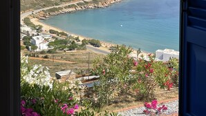 Vista costeira com uma montanha ao fundo, uma praia e alguns edifícios.