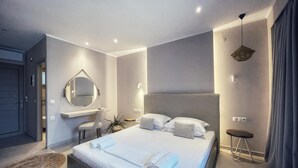 Quarto moderno com cama grande, mesas de cabeceira, um espelho e luminária suspensa.