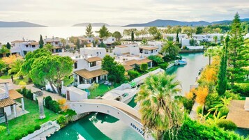 Zona residencial costeira com edifícios brancos, um canal e uma ponte.