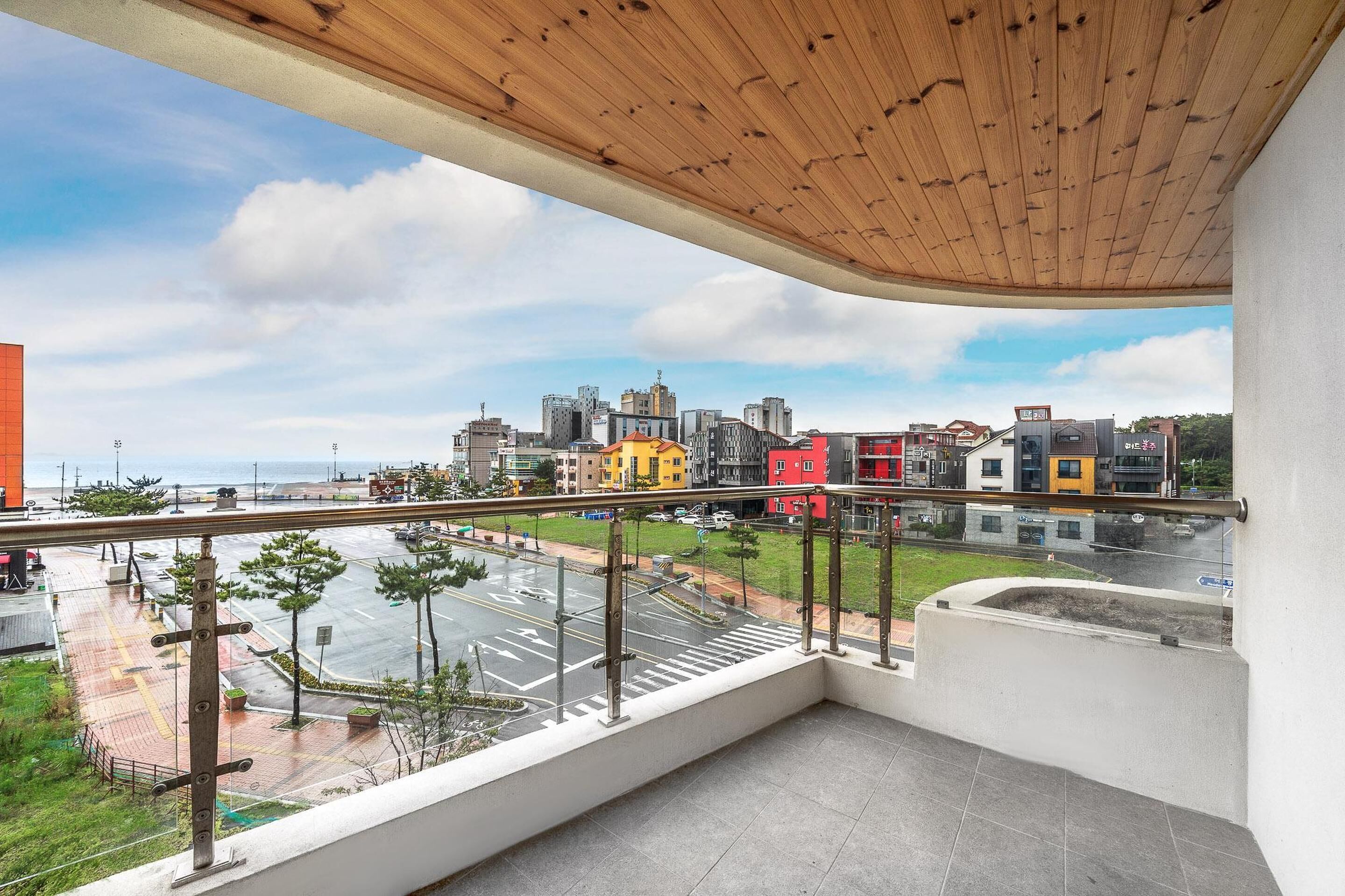 Uma varanda com vista para um horizonte urbano, incluindo edifícios e uma estrada.