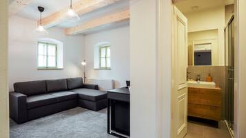 Uma sala de estar moderna com sofá modular, uma escrivaninha preta e iluminação pendente.
