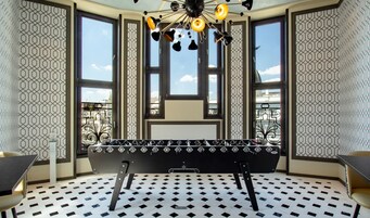 Um quarto com piso estampado, um banco e um lustre.