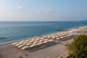 Uma praia privada, espreguiçadeiras, guarda-sóis de praia 