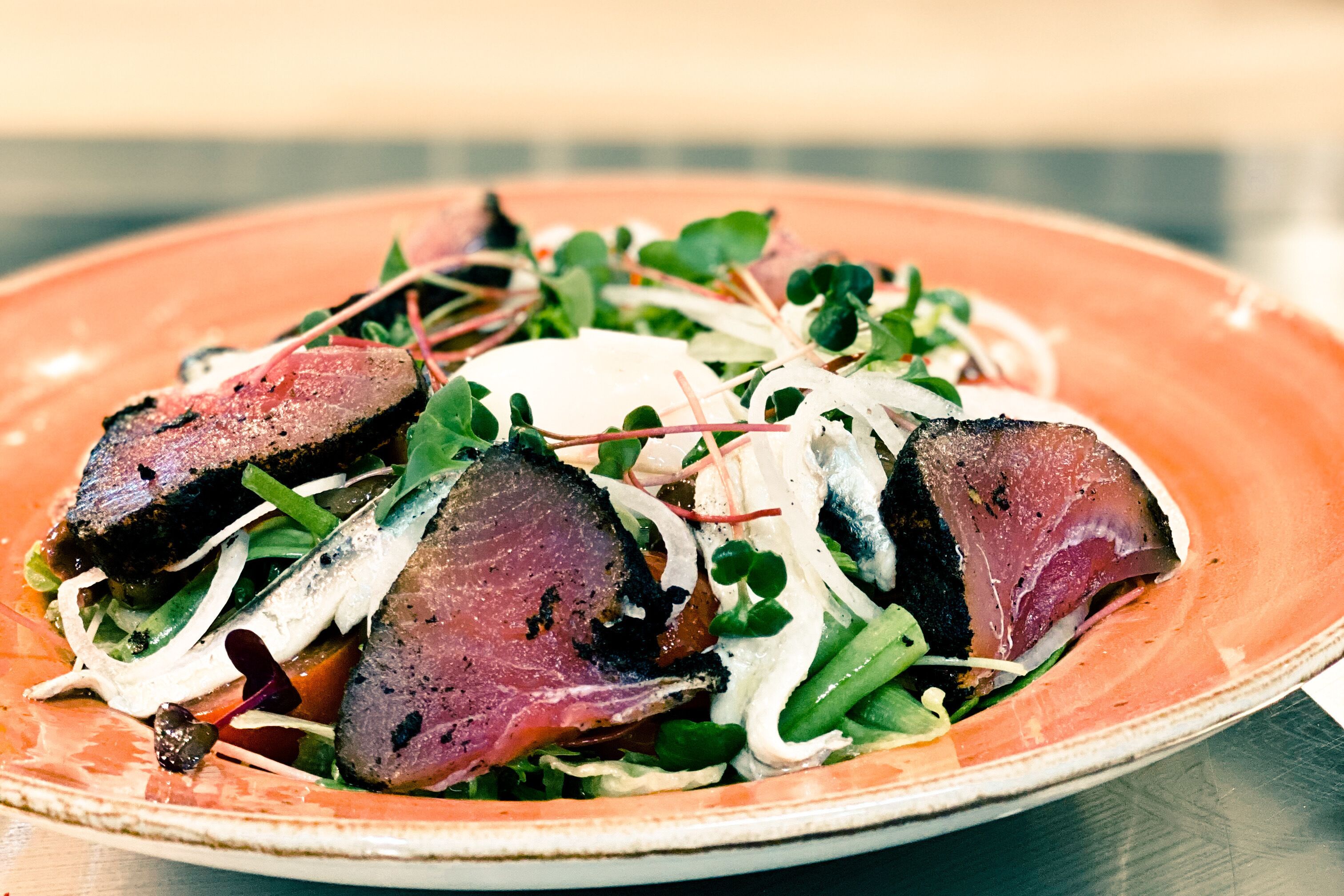 Prato de comida com fatias de carne e vegetais.