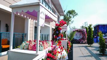 Um hotel boutique com uma varanda decorada com sacolas e flores coloridas.