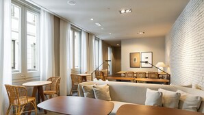 Um interior moderno com sofá, área de refeições e grandes janelas.