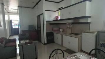Um espaço compacto com cozinha compacta, área de refeições e um pequeno espaço para sentar.