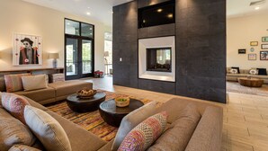 Uma sala de estar moderna com lareira, assentos confortáveis e uma janela grande.