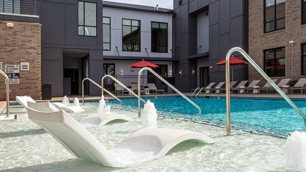 Uma área de piscina com espreguiçadeiras e um recurso aquático.