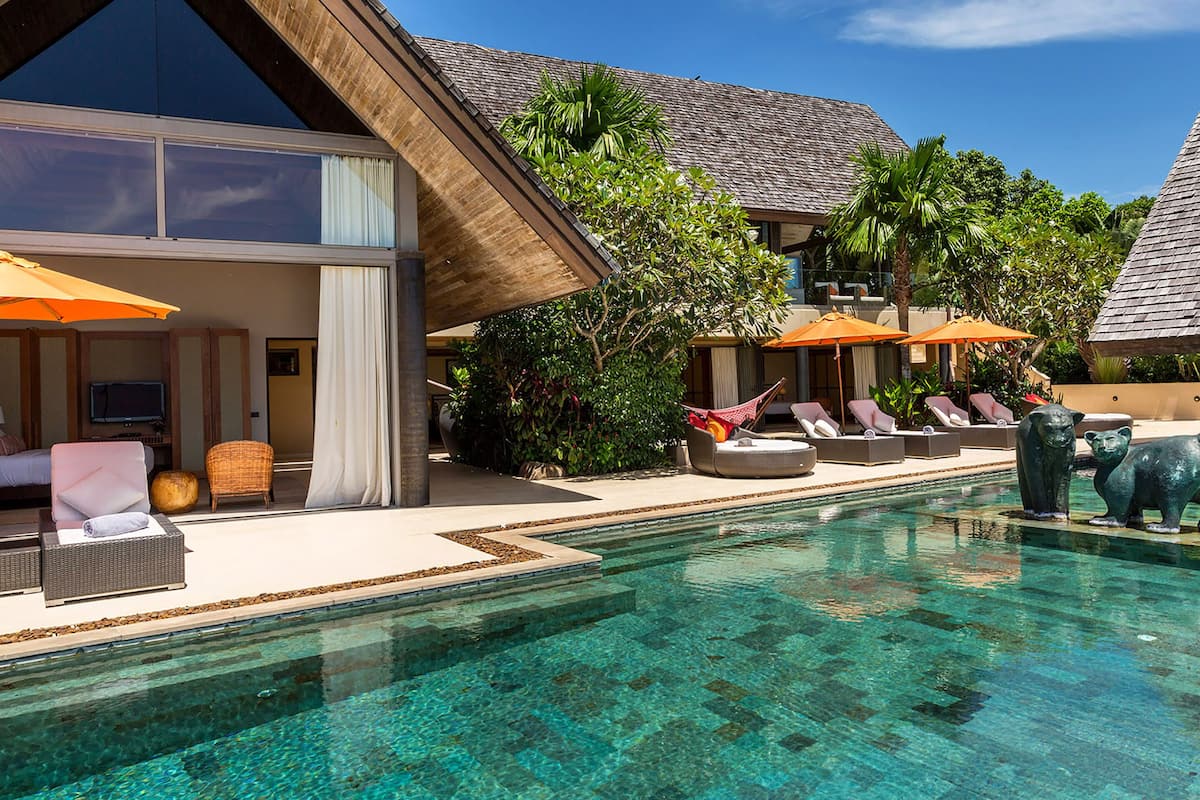 Um resort com piscina, espreguiçadeiras e guarda-sóis.