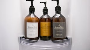 Três frascos de produtos Orange Rose em uma prateleira.