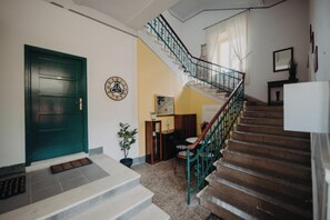 Uma escada com corrimão verde que leva a um patamar.