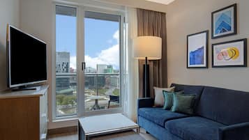 Suíte, 1 quarto, sacada | Área de estar | TV LED 55 polegadas com canais a cabo, TV, escritórios