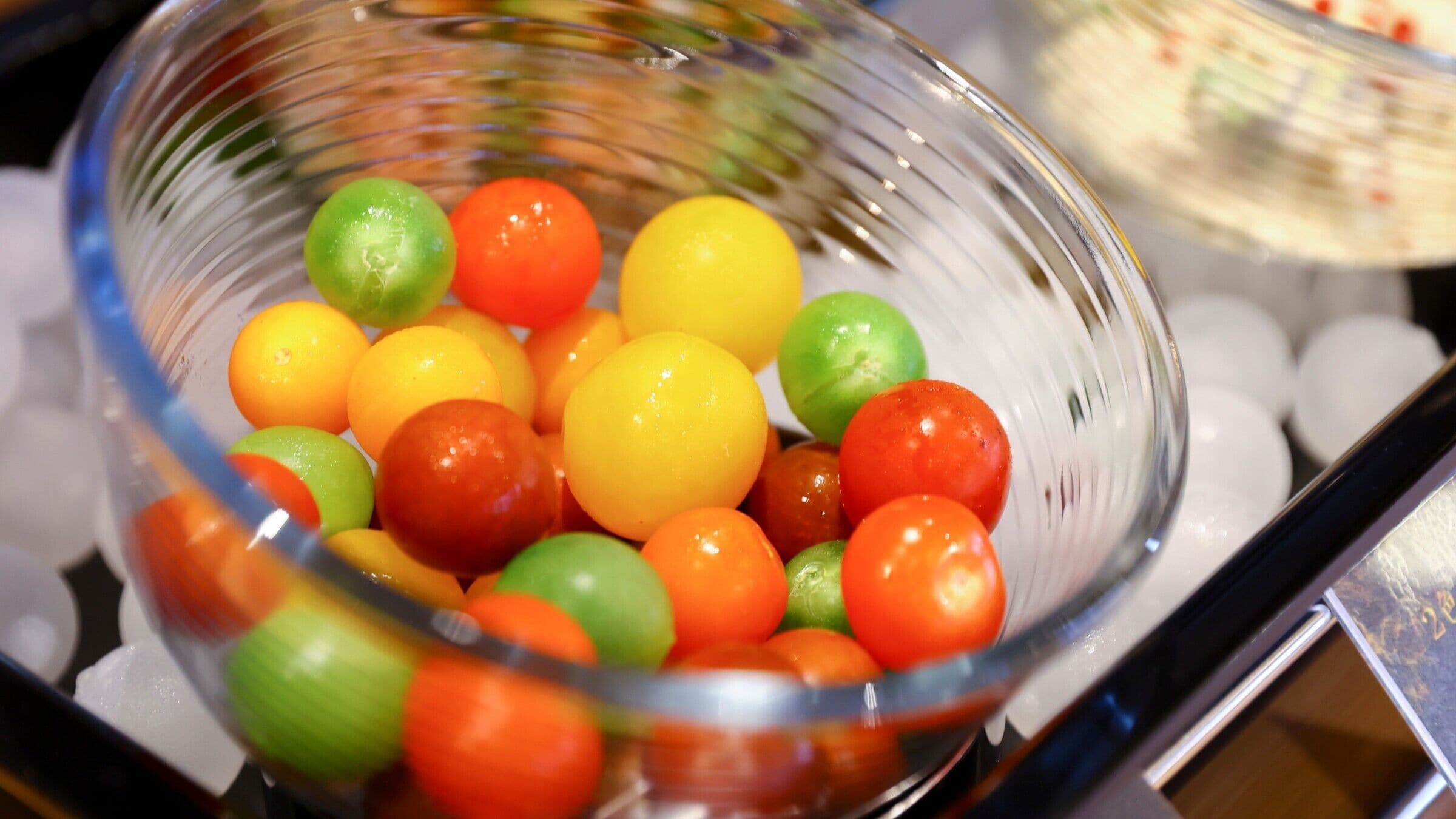 Uma tigela de vidro cheia de objetos esféricos coloridos.
