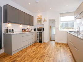 Um frigorífico, uma máquina de lavar louça, utensílios de cozinha 