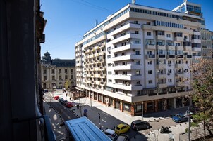 Um edifício de vários andares com design arquitetônico moderno, com varandas e um pátio central.