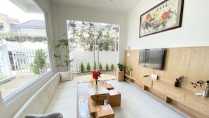 Uma sala de estar moderna com sofá, mesa de centro e rack para TV.