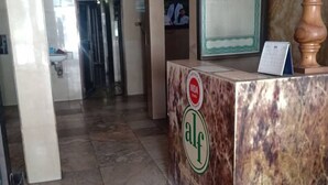 Uma mesa de recepção com tampo de mármore e uma placa com a inscrição 'NIDA'.