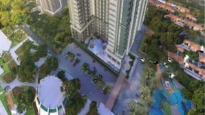 Um edifício alto com vários andares, rodeado por vegetação e uma piscina.