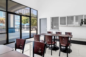 Uma área de refeições moderna com grandes janelas, decoração em branco e vista para o exterior.