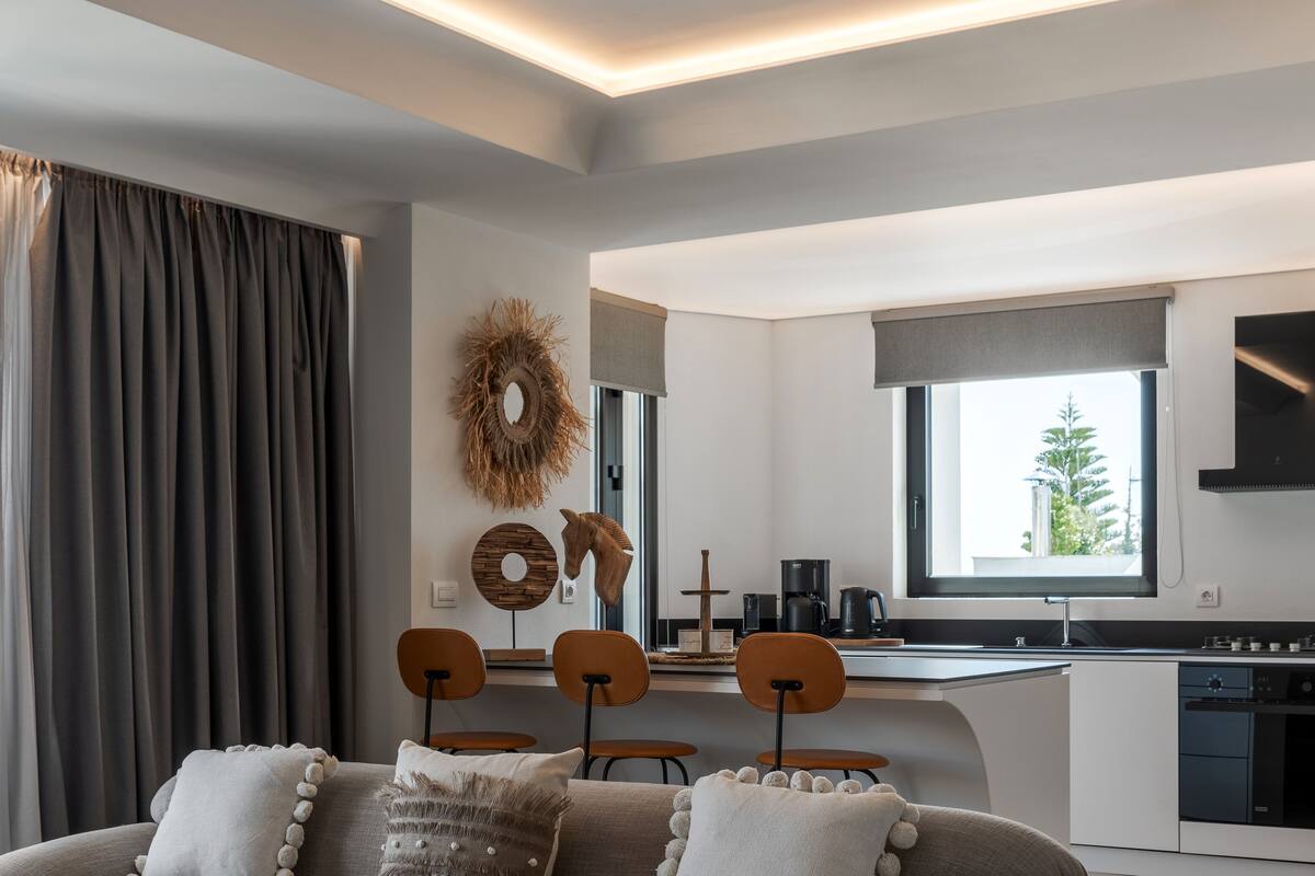 Uma sala de estar moderna com sofá, área de jantar com cadeiras, cozinha equipada e vista para a cidade.