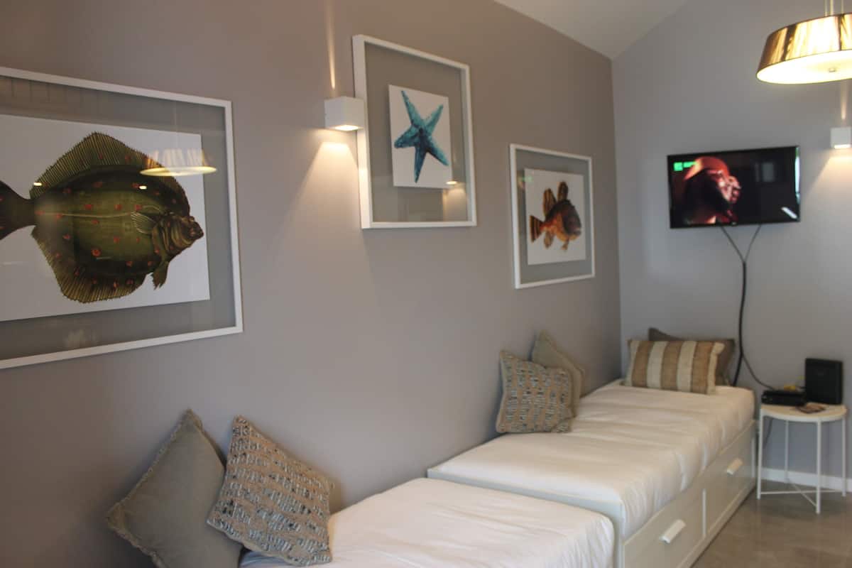 Quarto de hotel com cama, televisão e quadros na parede.