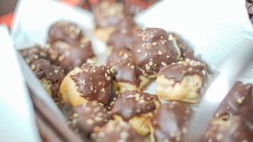 Uma cesta com doces de chocolate e nozes, colocada sobre um guardanapo branco.