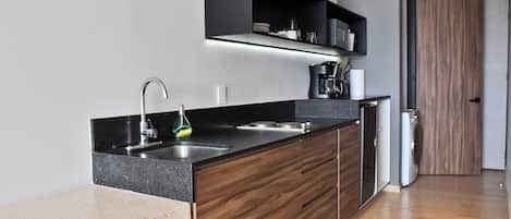 Uma cozinha moderna com bancada preta, armários de madeira e eletrodomésticos embutidos.