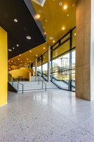 Um hall amplo com escada, janelas grandes e design moderno.