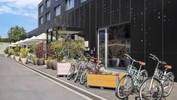 Uma fileira de bicicletas estacionadas em frente a um edifício moderno com fachada preta.