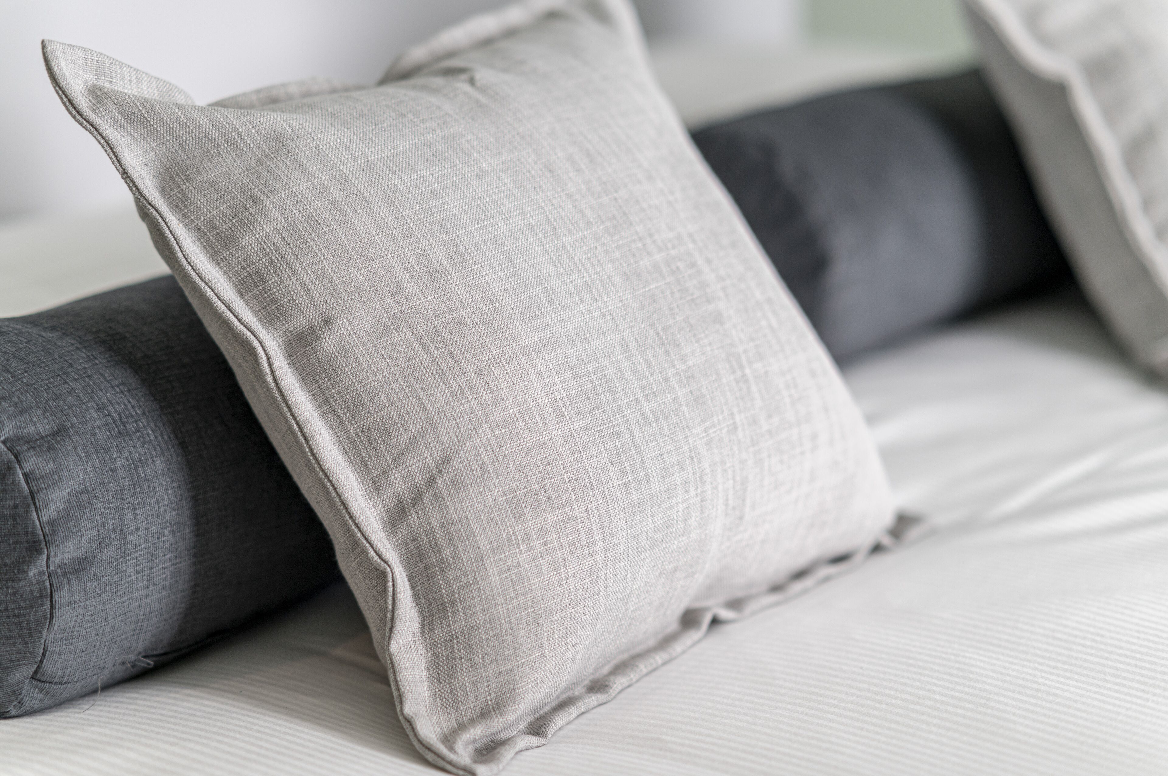Um close-up de uma cama com travesseiro cinza e preto.