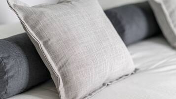 Um close-up de uma cama com travesseiro cinza e preto.