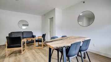 Uma sala de estar moderna com um sofá, cadeiras, uma mesa de centro e uma mesa de jantar.