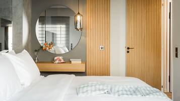 Um quarto com uma cama, uma mesa de cabeceira, um espelho, uma luminária pendente e um guarda-roupa de madeira.