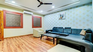 Sala de estar com sofá, poltrona, mesa de centro e ventoinha no teto.