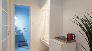 Casa de banho com lavatório, porta-toalhas e um pequeno frigorífico.