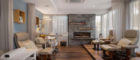 Uma sala de estar moderna com lareira, sofás de couro e uma parede de destaque em pedra.