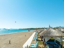 Uma praia privada, toldos de praia (sobretaxa), espreguiçadeiras 