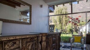 Quarto com um espelho grande, um armário de madeira e uma cadeira com almofada amarela.