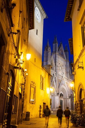 Uma rua estreita com uma grande catedral ao fundo.