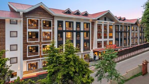 Um hotel com vários andares, arquitetura tradicional, com varandas e grandes janelas.