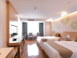 Quarto de hotel com televisão, duas camas, uma mesa e uma cadeira.