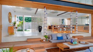 Uma sala de estar moderna com sofá, mesa de centro e área de jantar com cadeiras.