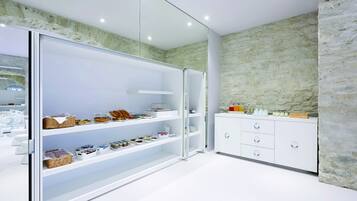 Quarto moderno, bem iluminado, com divisória de vidro, armários brancos e parede de pedra.