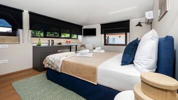 Quarto moderno com cama, mesa de cabeceira e vista para o exterior.