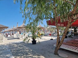 Perto da praia, praia de areia branca, espreguiçadeiras 