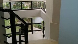 Interior com vários níveis e uma escadaria que leva a um andar superior.