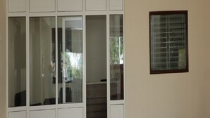 Um quarto com uma grande porta de correr, uma janela com persianas e um chão em mosaico.