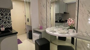 Uma cozinha moderna com uma mesa de jantar redonda, banquetas pretas e um espelho grande.