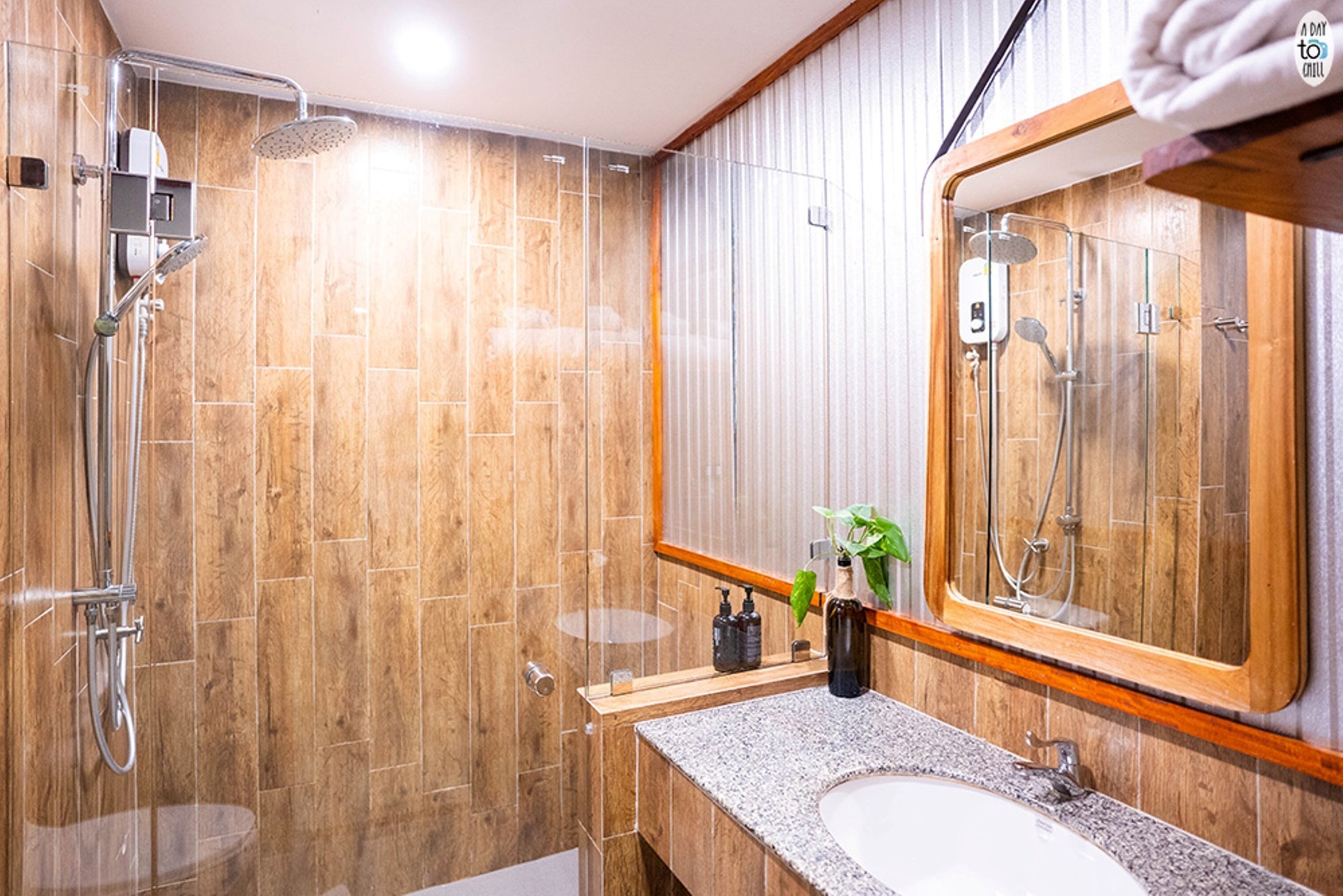 Uma casa de banho moderna com toucador de madeira, um espelho grande e zona de duche.